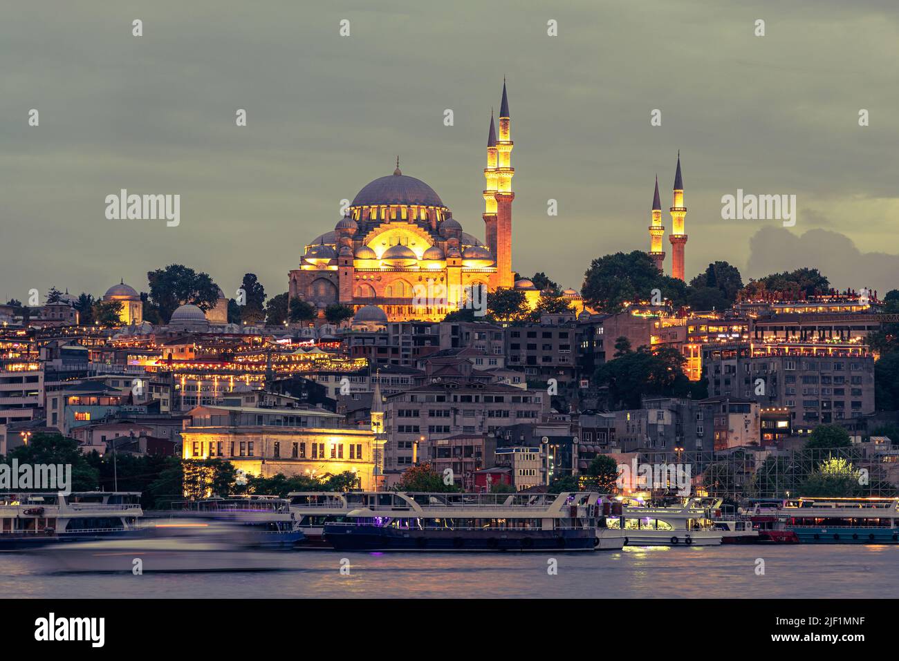 Suleymaniye Mosque with night illumination and minaret of Rustem Pasha Mosque, Istanbul, Turkey ...