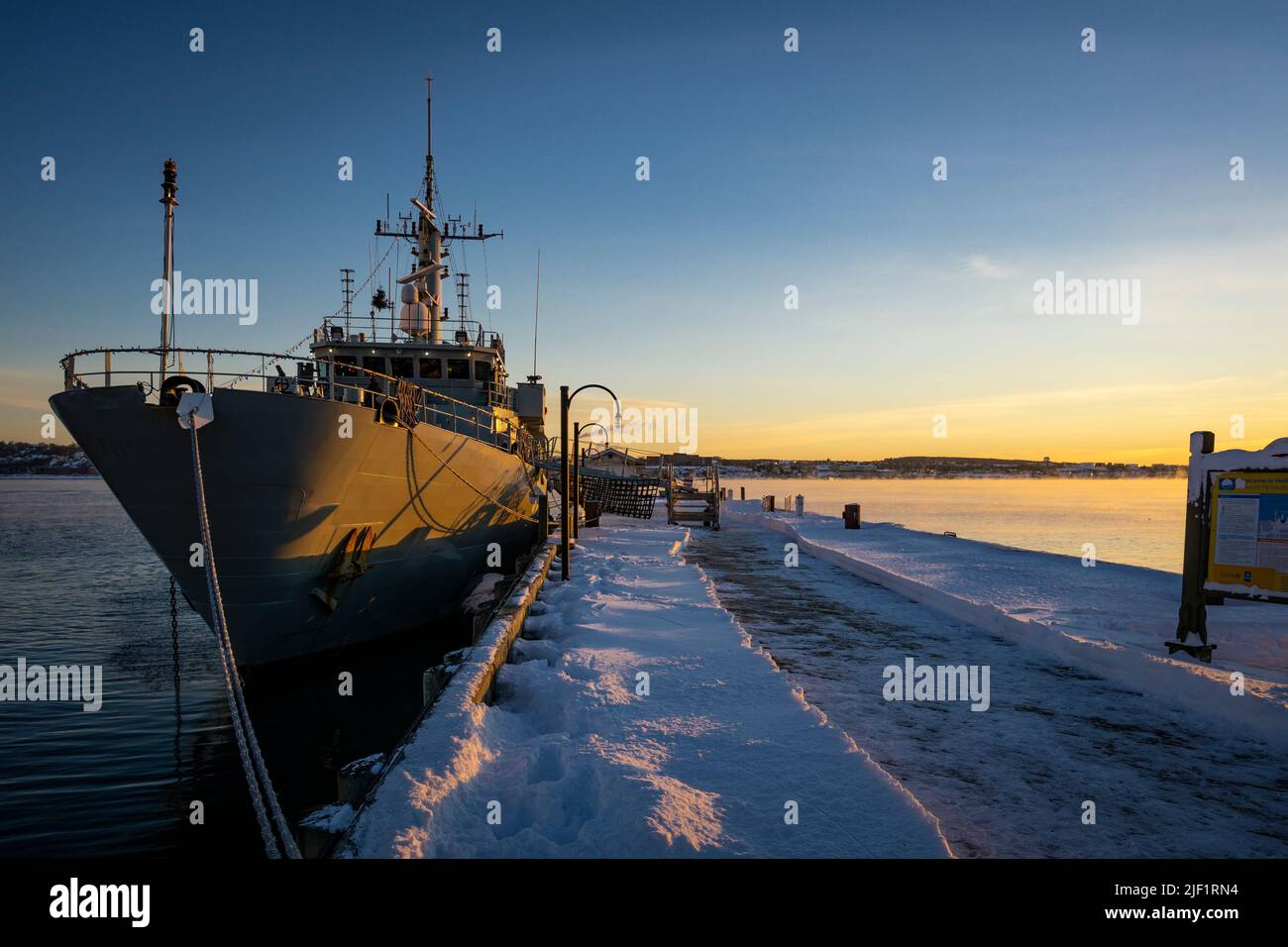 Minesweeper HMCS Kingston alongside a snow-covered wharf at Christmas ...