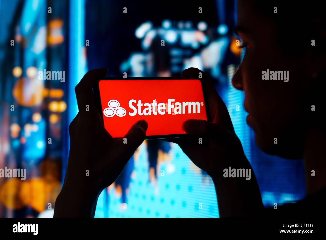 In this photo illustration, a silhouetted woman holds a smartphone with ...