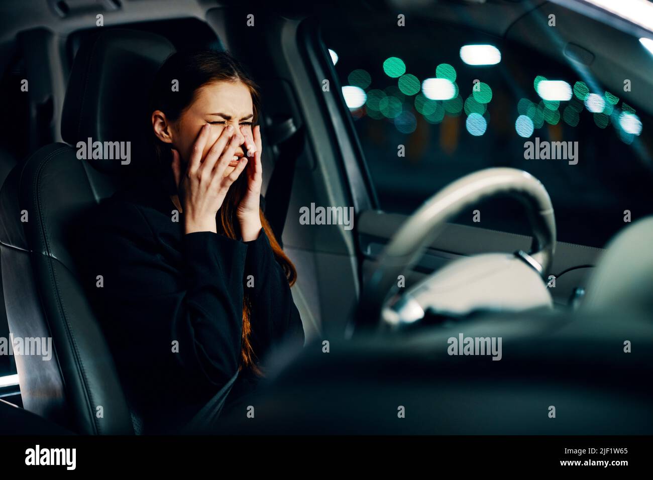 a frustrated, emotional, crying woman is sitting behind the wheel of a ...