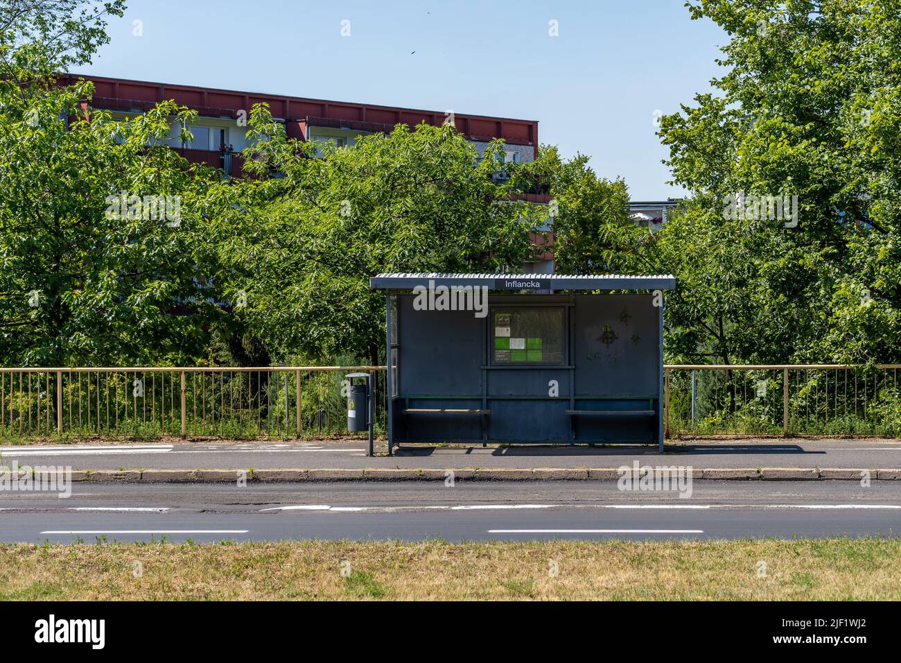 An empty bus stop by a road on a sunny day Stock Photo - Alamy