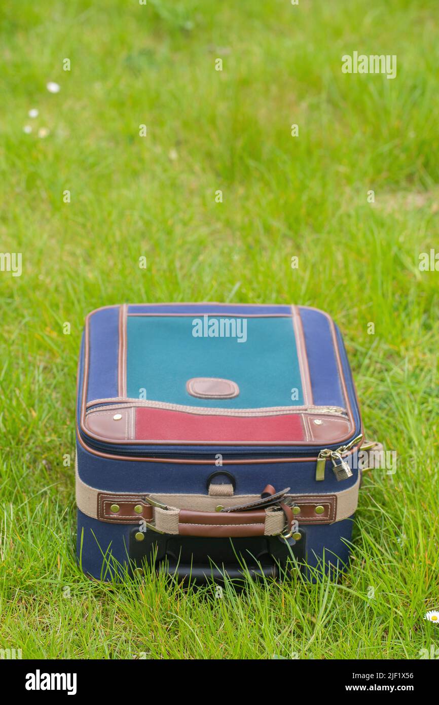 Old travel bag in lush green grass Stock Photo - Alamy