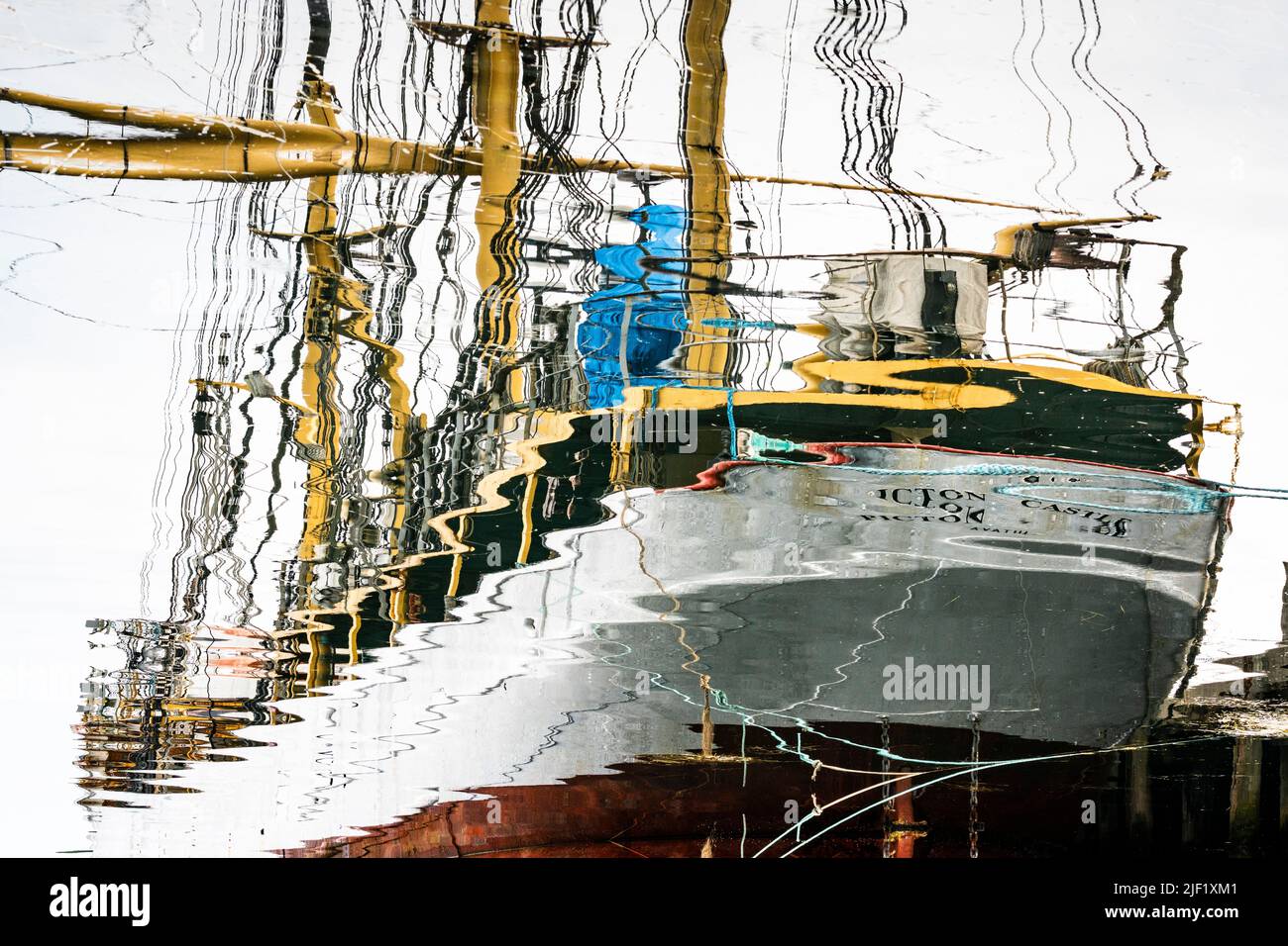 Reflection of the steel-hulled barque Picton Castle alongside a wharf ...