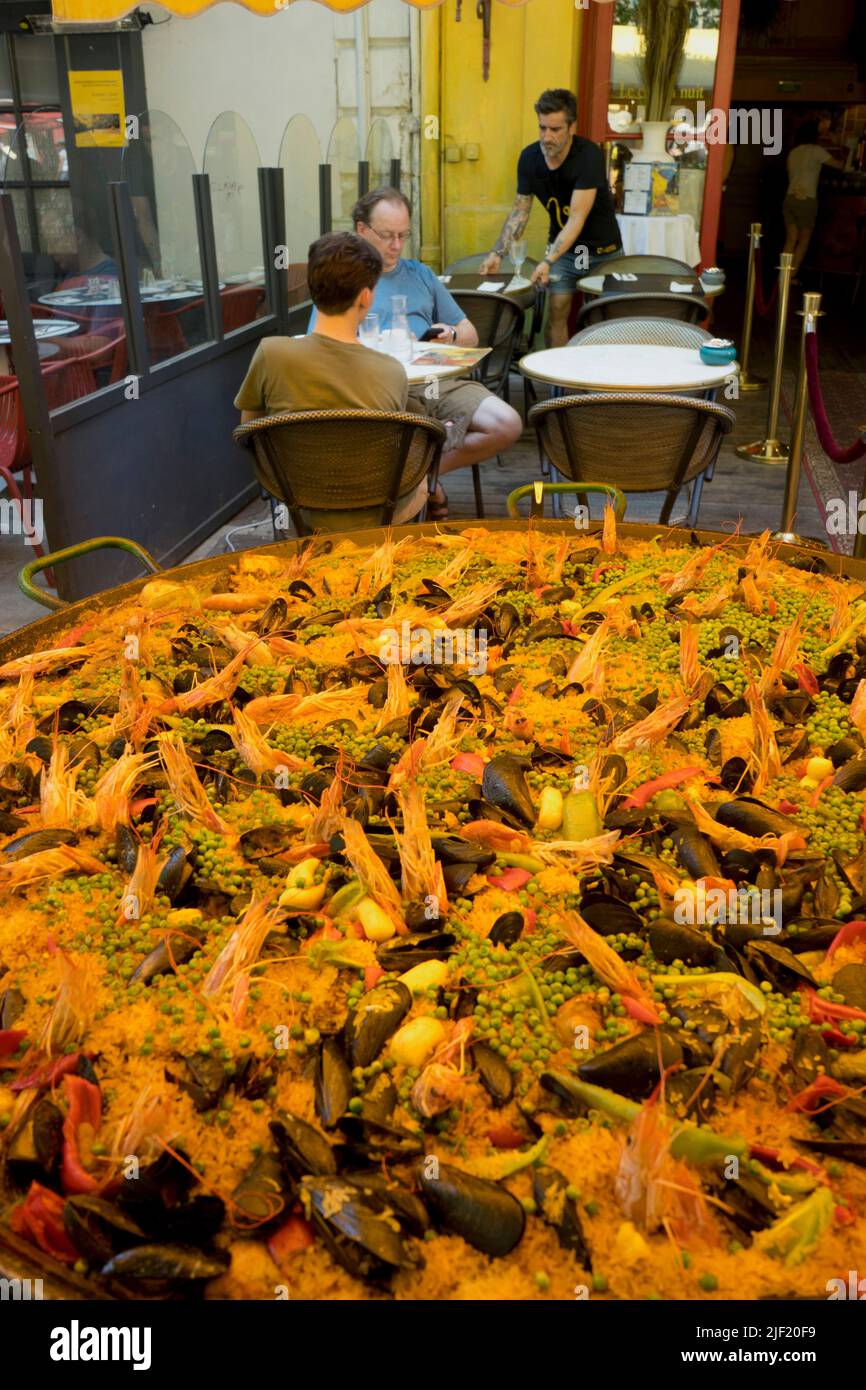 Customers at a restaurant serving paella in the town of Arles in the ...