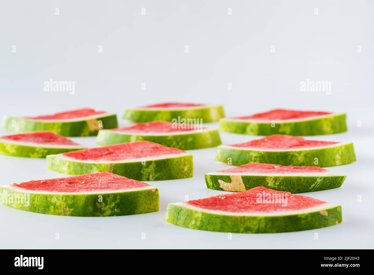 Slices of watermelon receding into a light background Stock Photo - Alamy