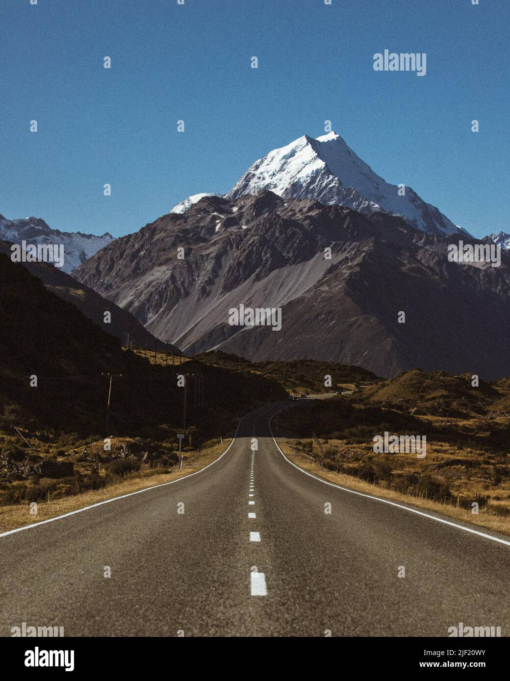 A vertical shot of an asphalt road leading to Mount Cook in New Zealand ...