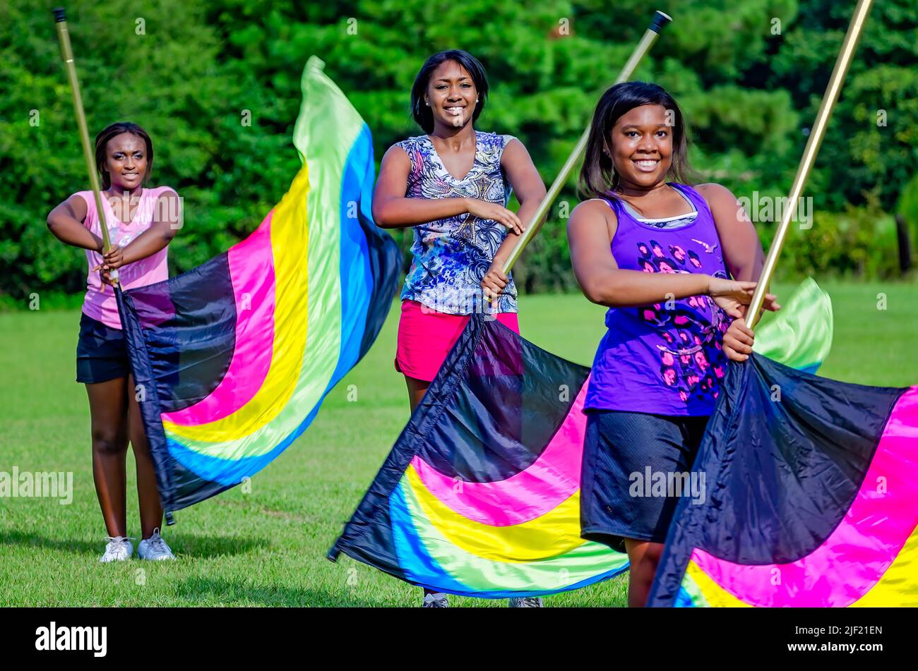 Members of the Columbus High School color guard twirl their flags ...