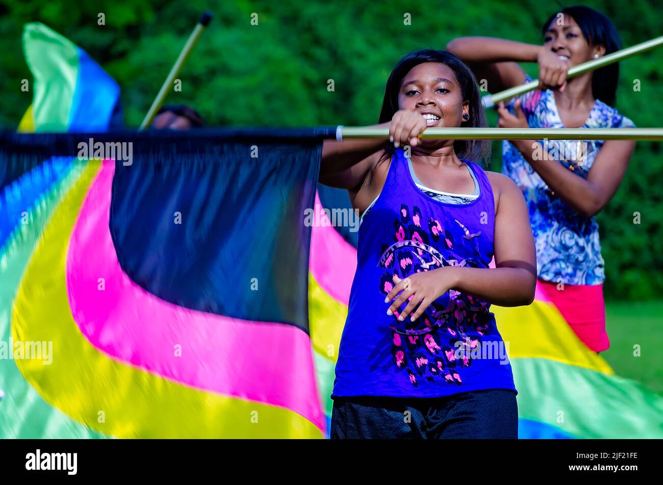 Members of the Columbus High School color guard twirl their flags ...