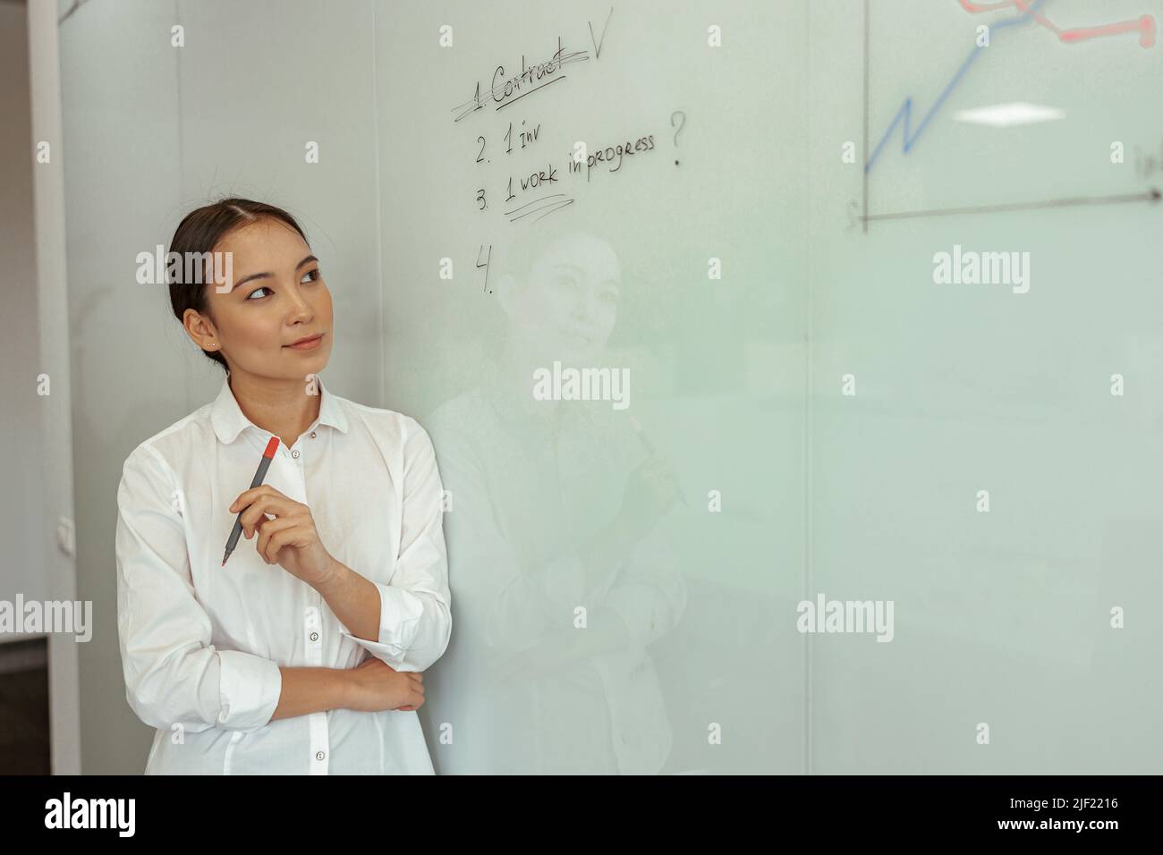 Asian business woman looking on flipboard with charts stand in meeting ...