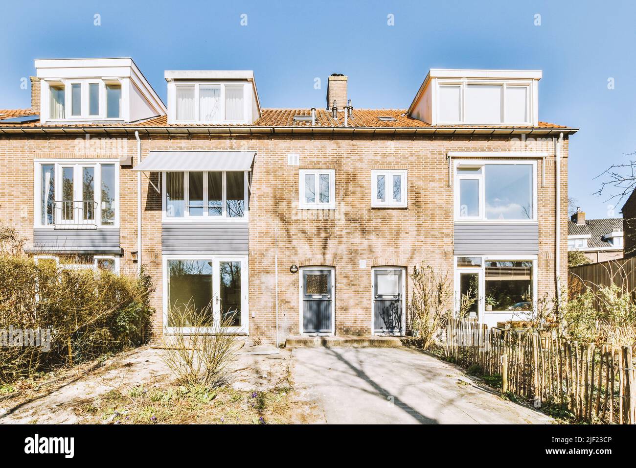 Front view of a brick building with skylights and wooden doors leading ...