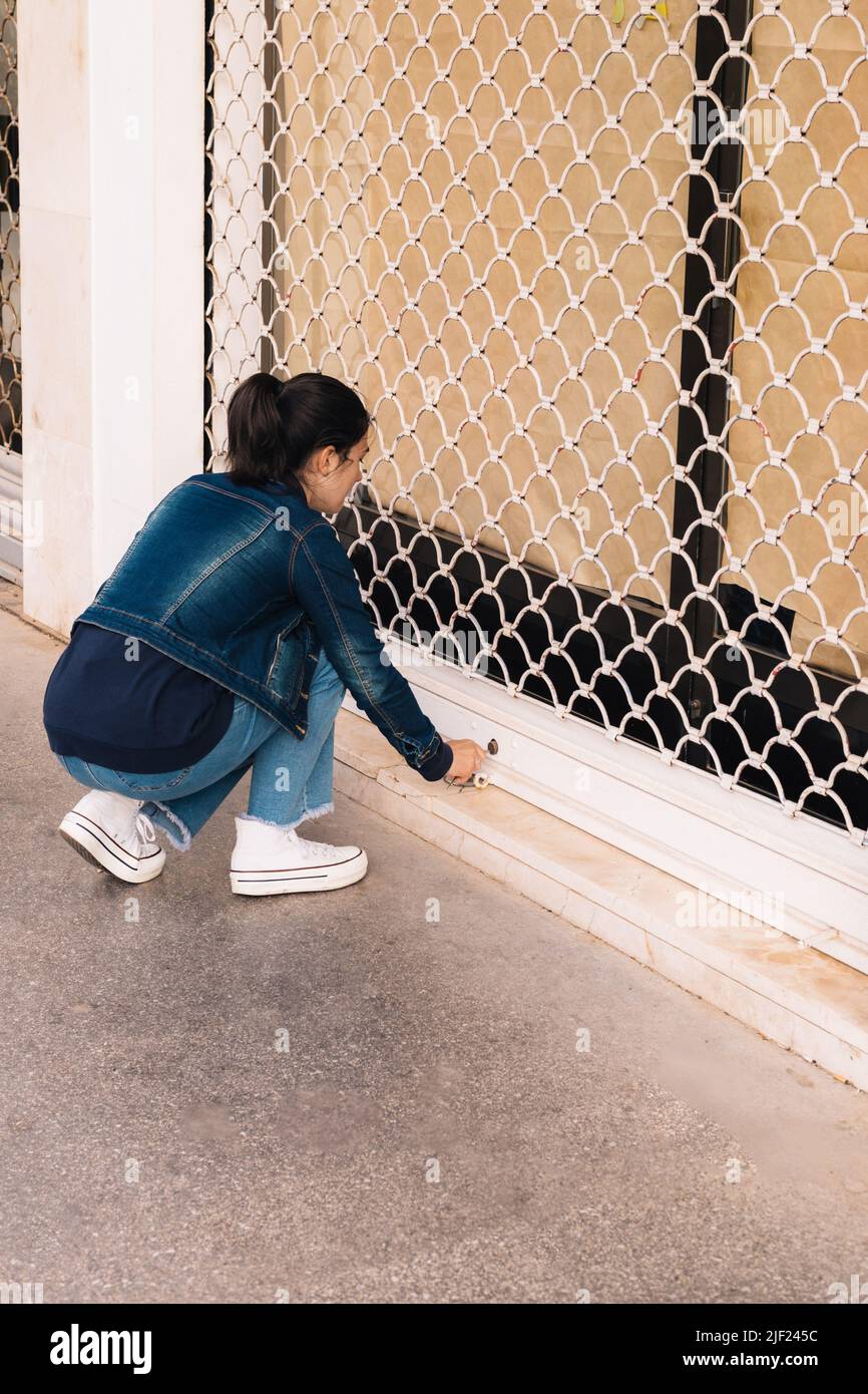young girl closing business gate with key as end of her business Stock ...