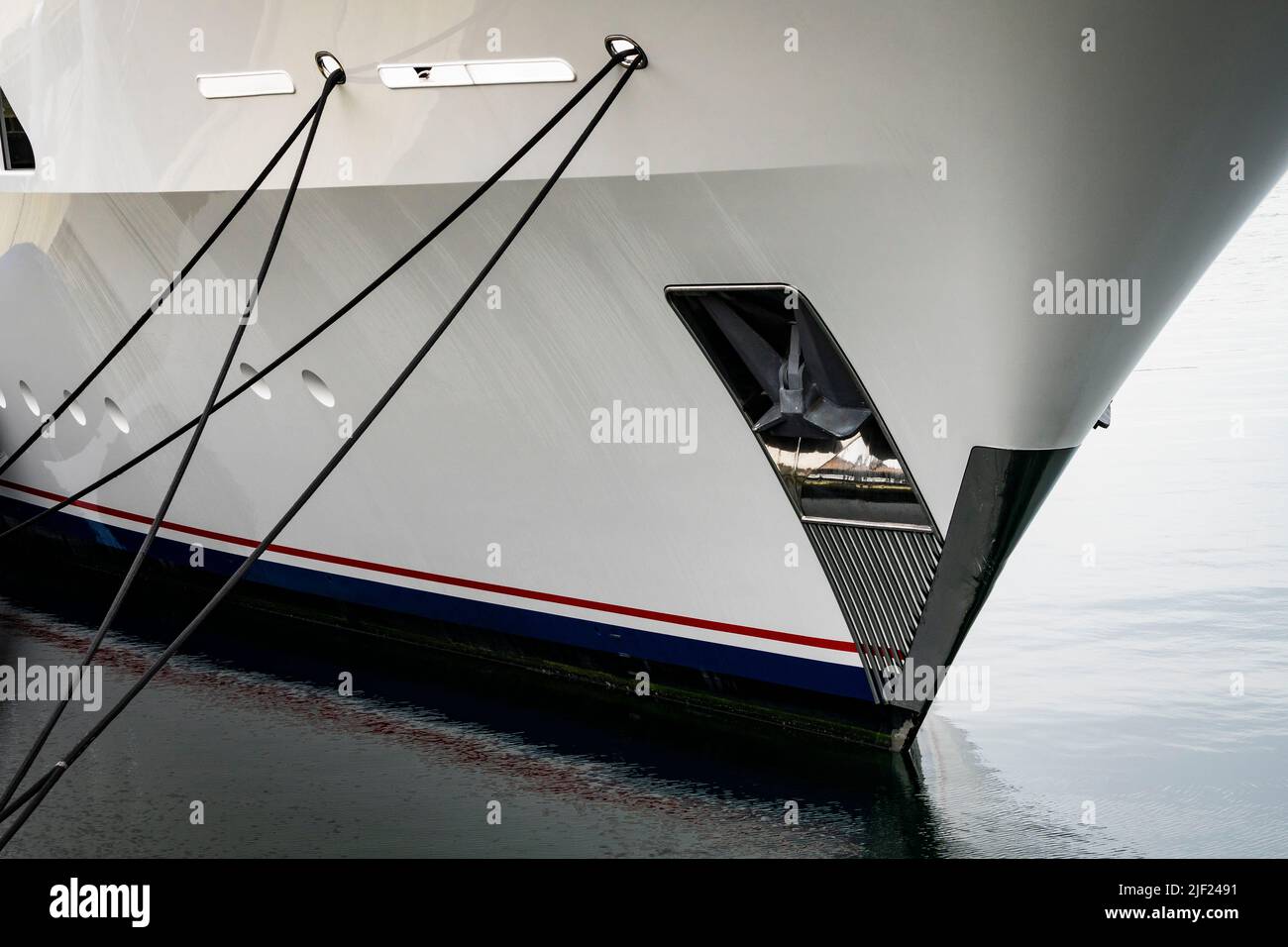 The anchor on the bow of a luxury yacht floating and reflecting on ...