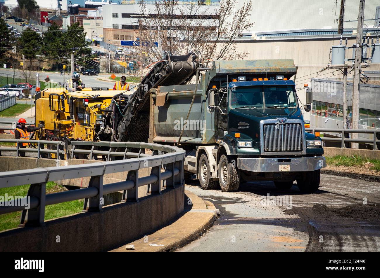 A Caterpillar asphalt removal planer strips asphalt from a ramp and ...