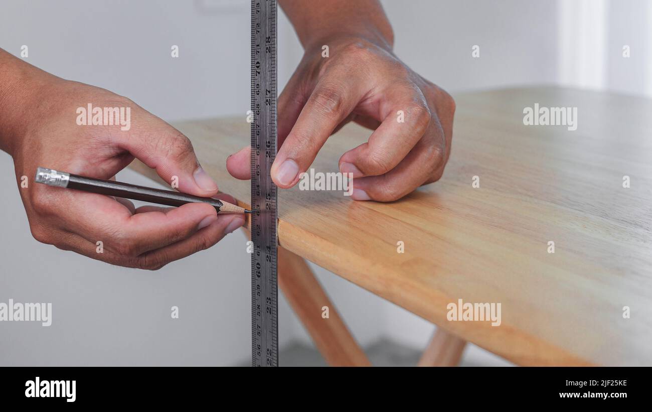 Measurement concept. Someone measures a handcraft of table by ruler ...