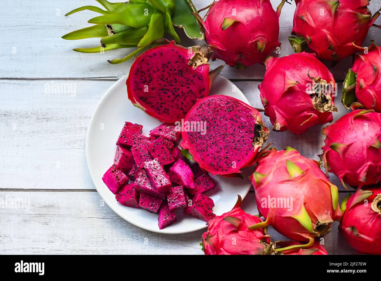 dragon fruit slice and cut half on white plate with pitahaya background ...