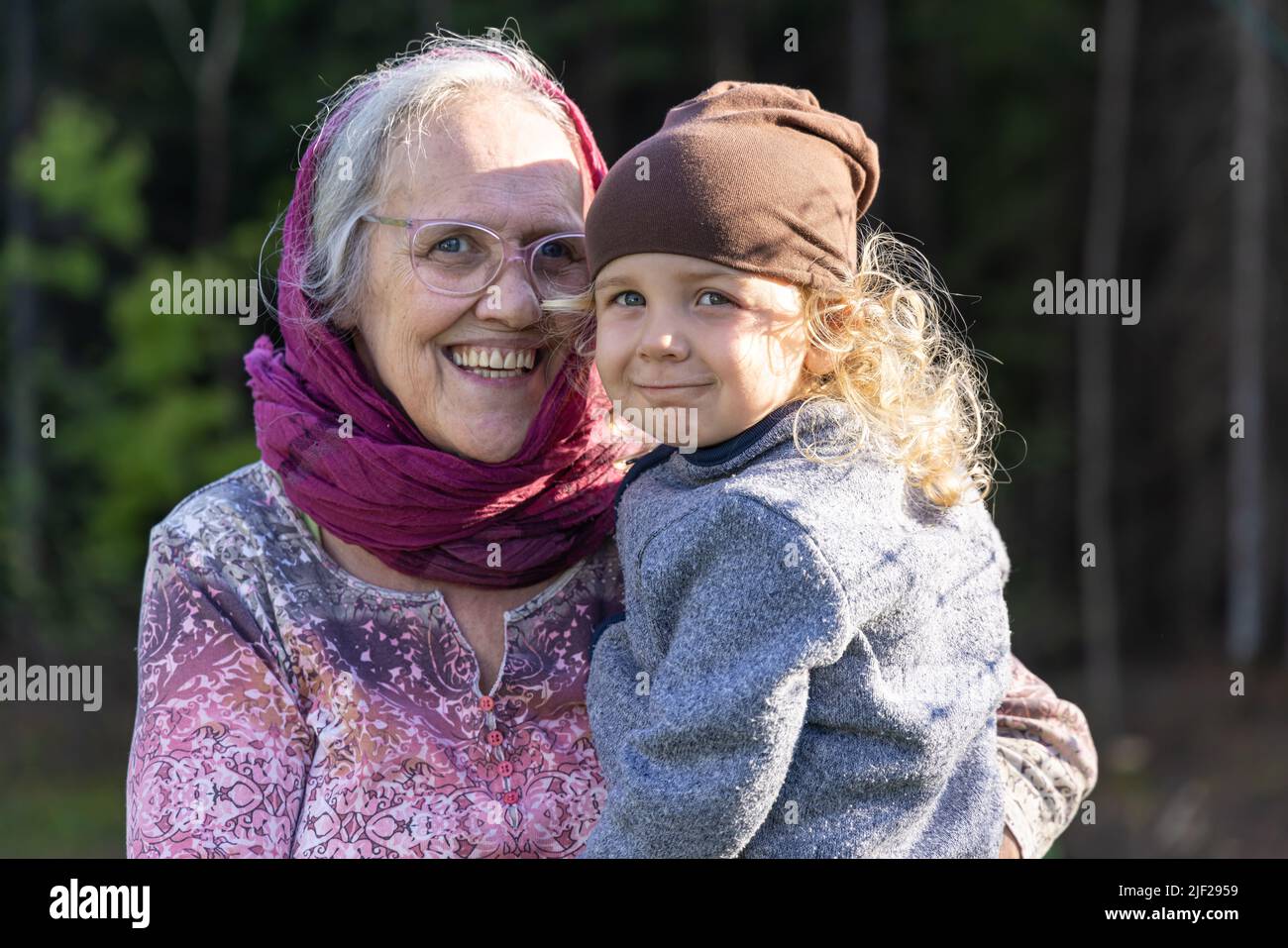 Joyful family portrait of an elderly grandmother and four year old ...