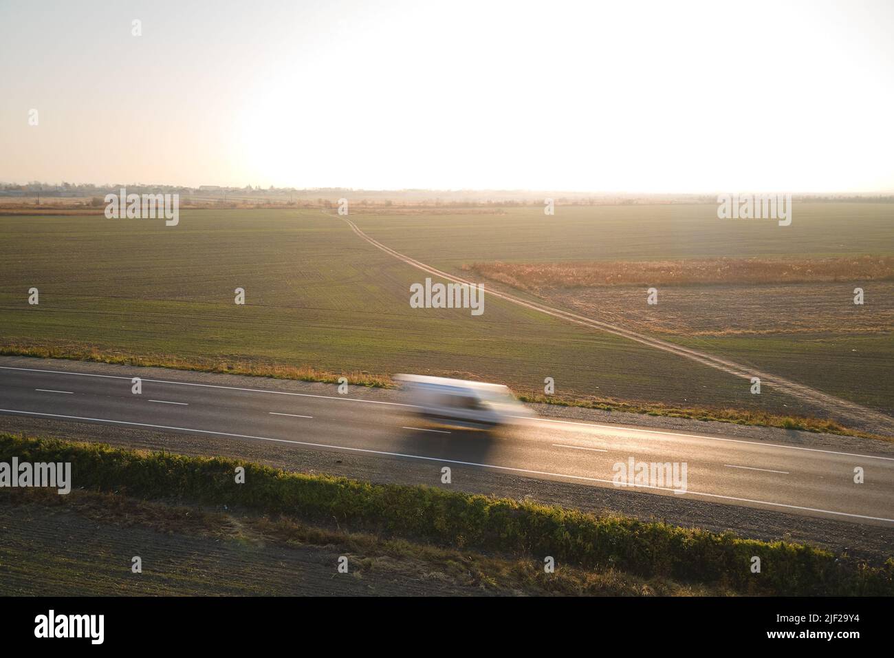 Aerial view of blurred fast moving cargo van driving on highway hauling ...