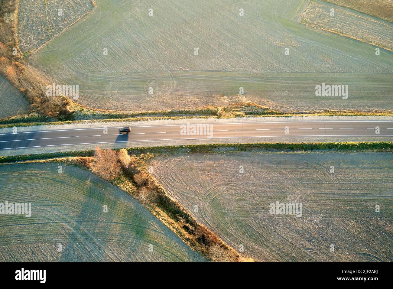 Aerial view of intercity road with blurred fast driving car at sunset ...