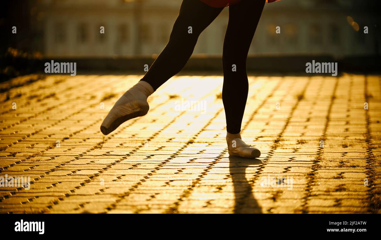 Feet of young woman ballerina dancing on the roof in the pointe shoes ...