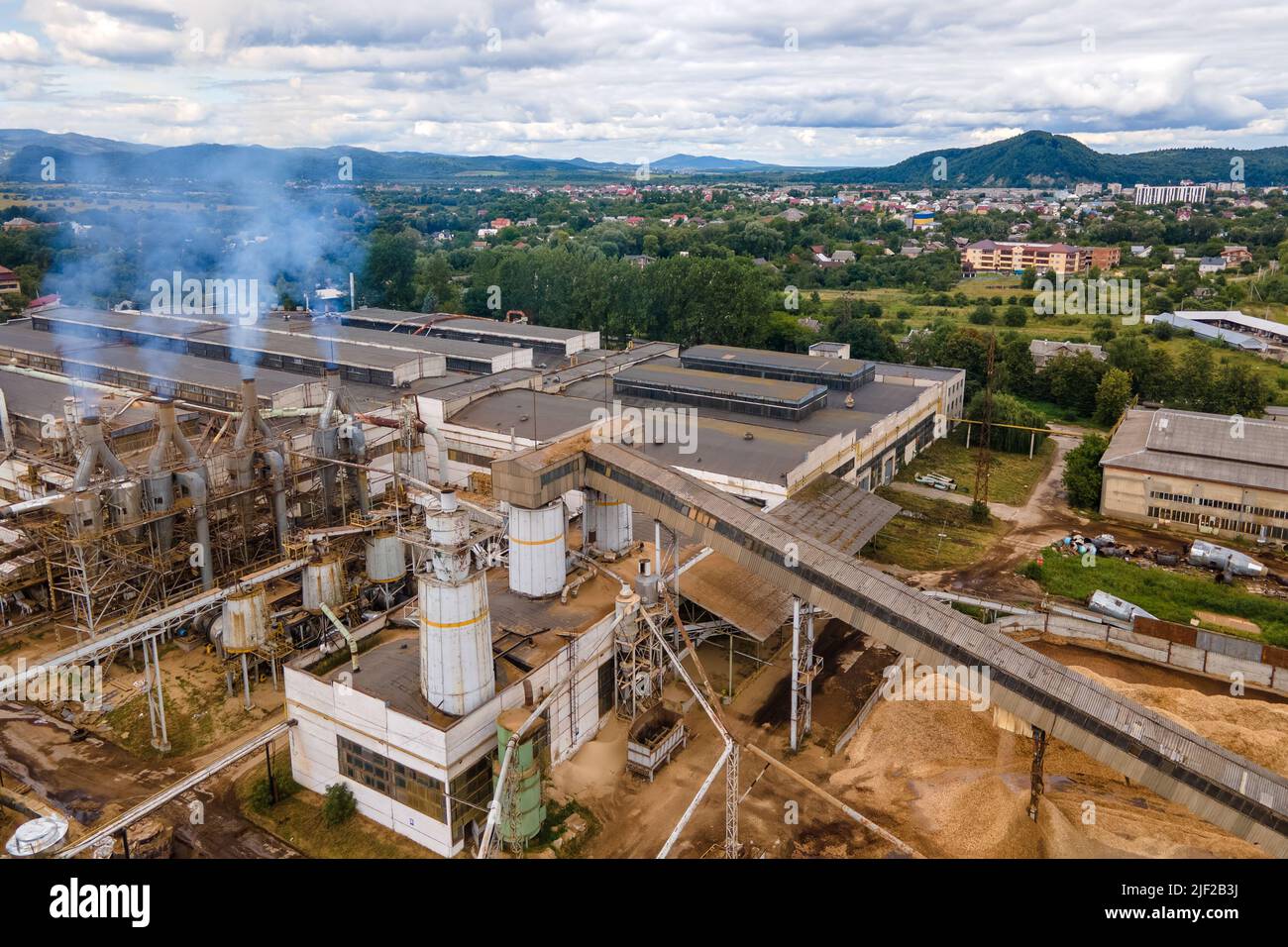 Aerial view of wood processing factory with smoke from production ...