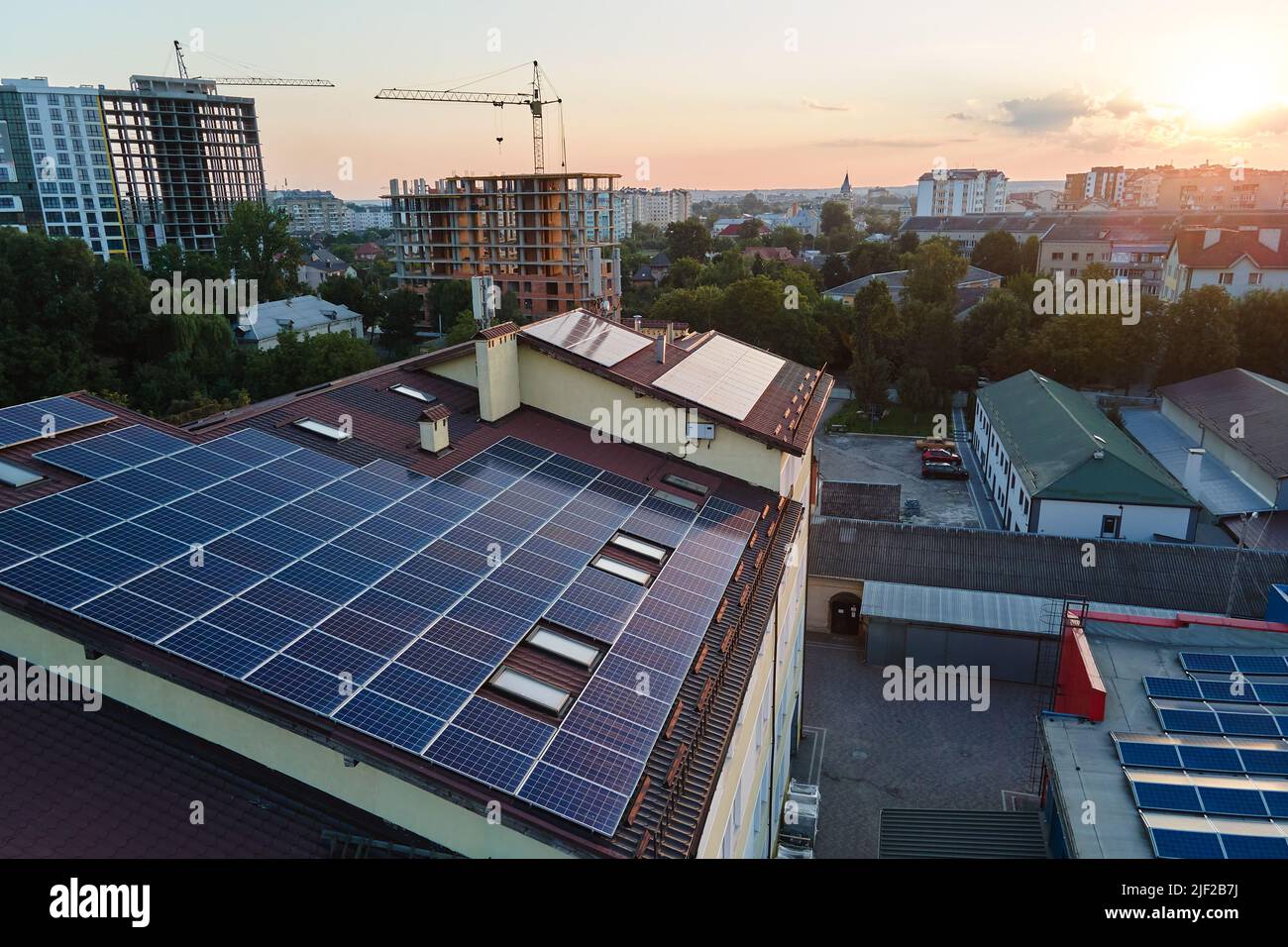 Blue photovoltaic solar panels mounted on building roof for producing ...