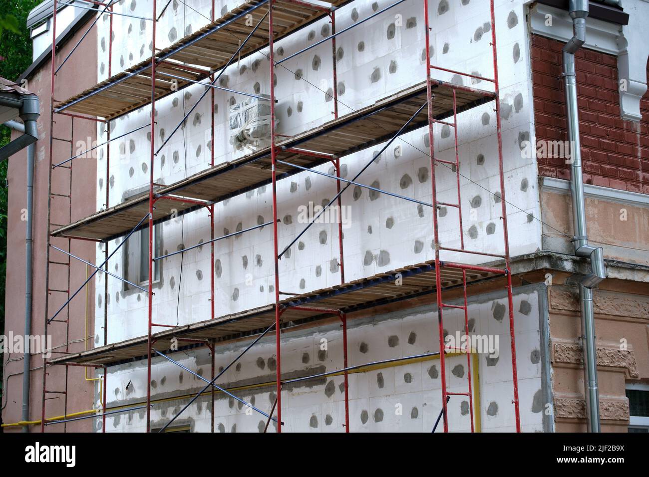 Building facade under renovation works with construction scaffolding ...