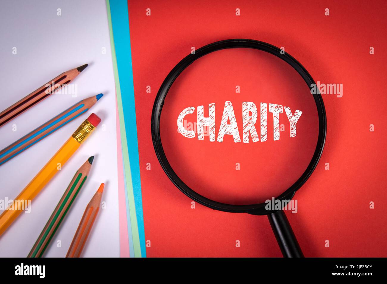 Charity Magnifying Glass Pencils And Colored Sheets Of Paper Stock charity-magnifying-glass-pencils-and-colored-sheets-of-paper-stock
