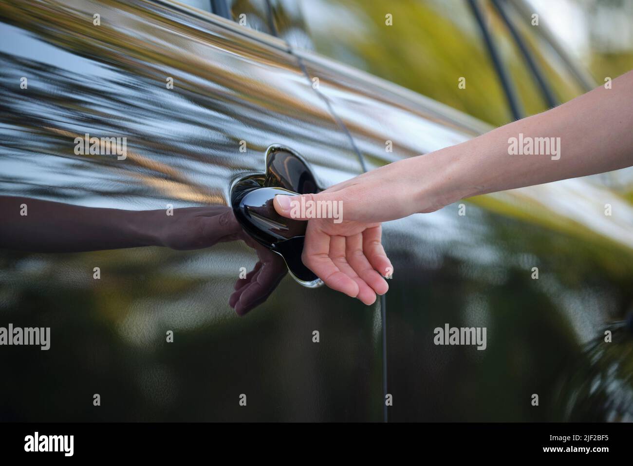 Closeup of driver hand opening car front door with touch ID finger ...