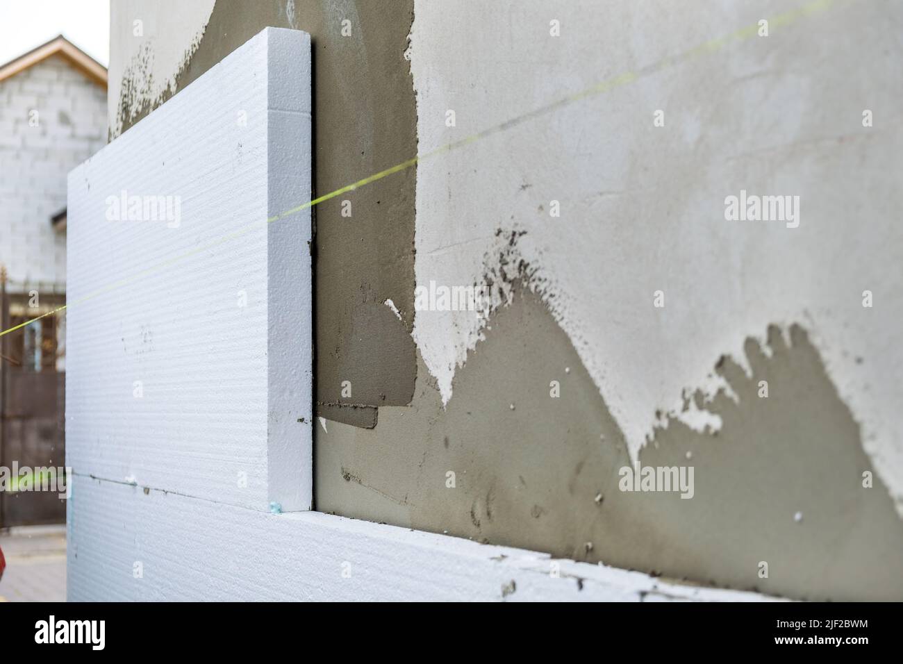 Installation of styrofoam insulation sheets on house facade wall for ...