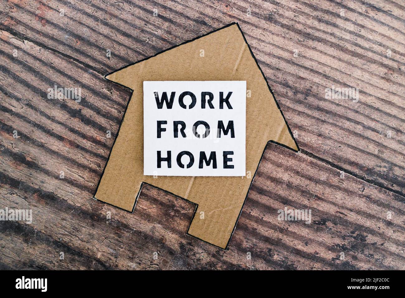 work from home sign with house icon made of cardboard over wooden ...
