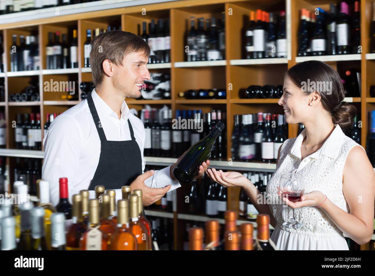 Happy seller man giving sample taste of wine Stock Photo - Alamy