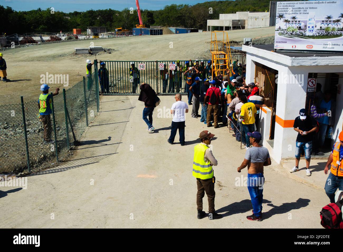 workers waiting for work at a building site with cement work with gates ...
