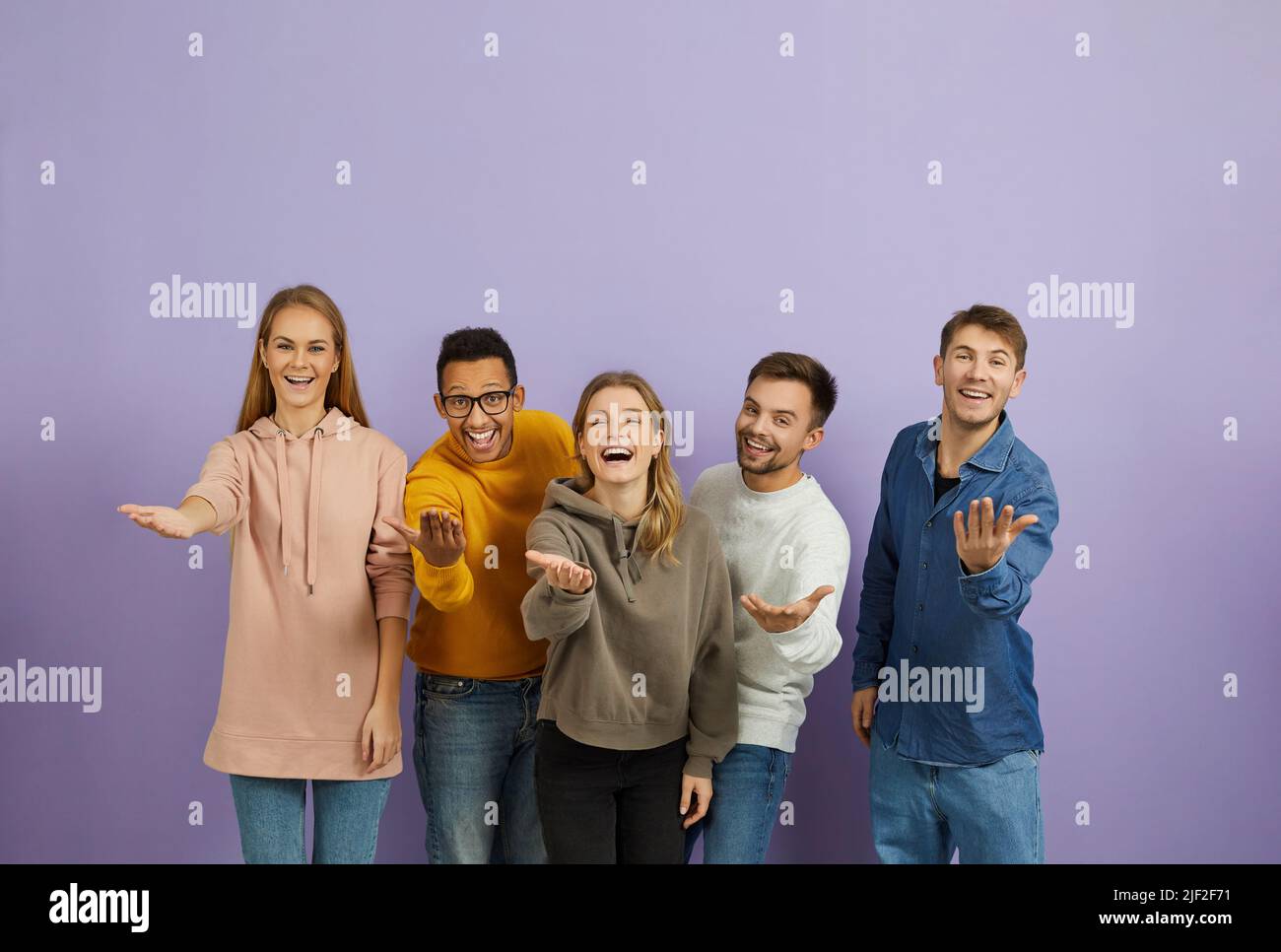 Group of happy young people saying 'Come here', smiling and doing an ...