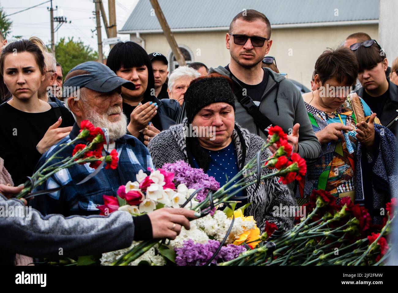 Mourners of the village attend the funeral of Sergey Titov. Family, relatives, and friends are ...