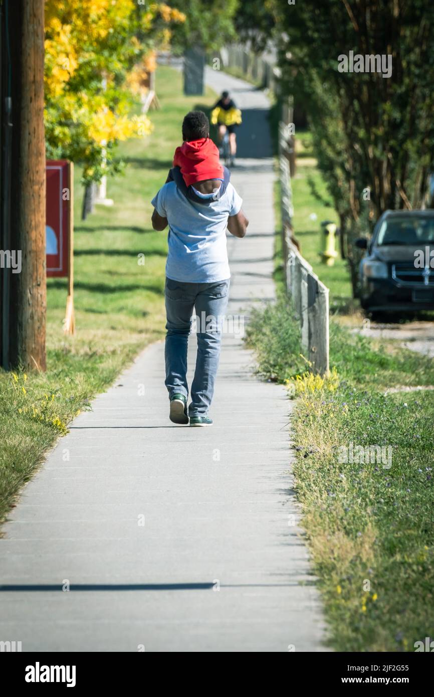 Man carrying child on his shoulder Stock Photo - Alamy