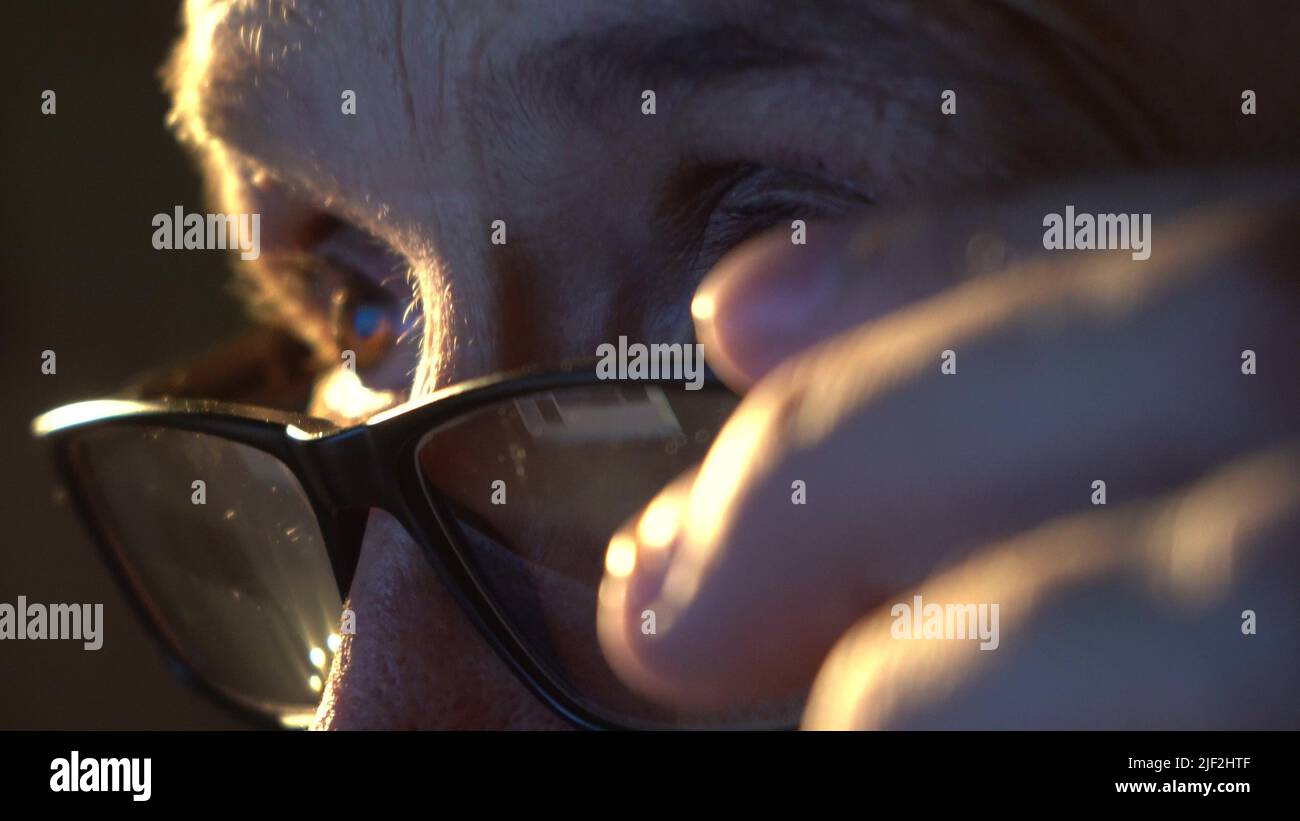 Close-up of the focused eyes of a businessman wearing computer glasses ...