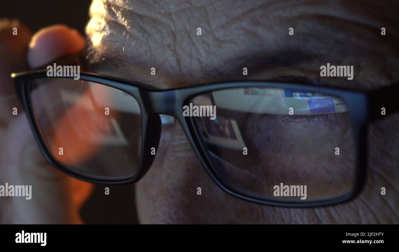 Close-up of the focused eyes of a businessman wearing computer glasses ...