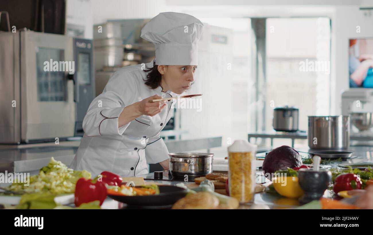 Authentic cook taste testing bad sauce on kitchen stove, preparing ...