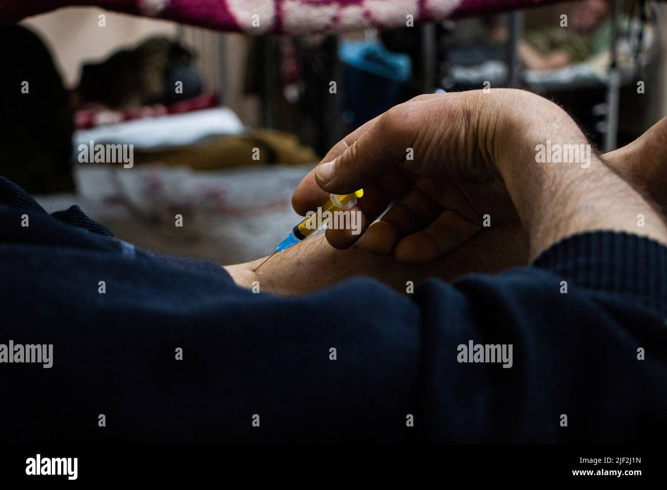 Soldier is injecting himself with a pain reliever, due to his strong ...