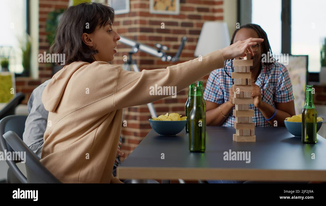 Cheerful people having fun with society games at home, playing with ...