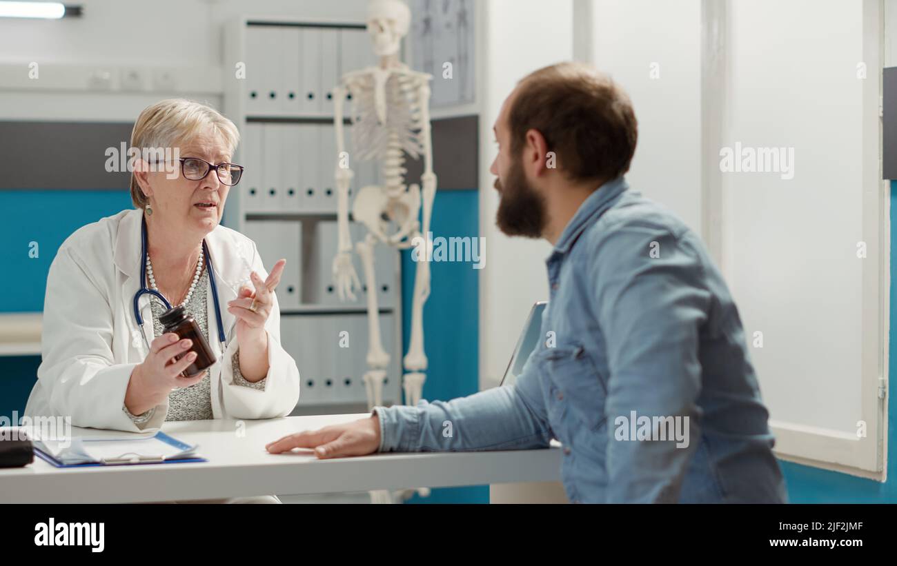 Female physician explaining prescription medicine in bottle, giving ...