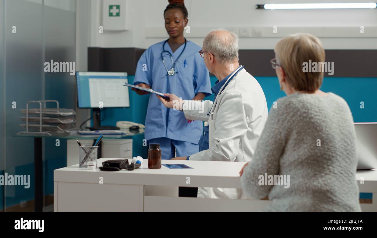 Retired woman signing appointment papers for prescription pills and ...