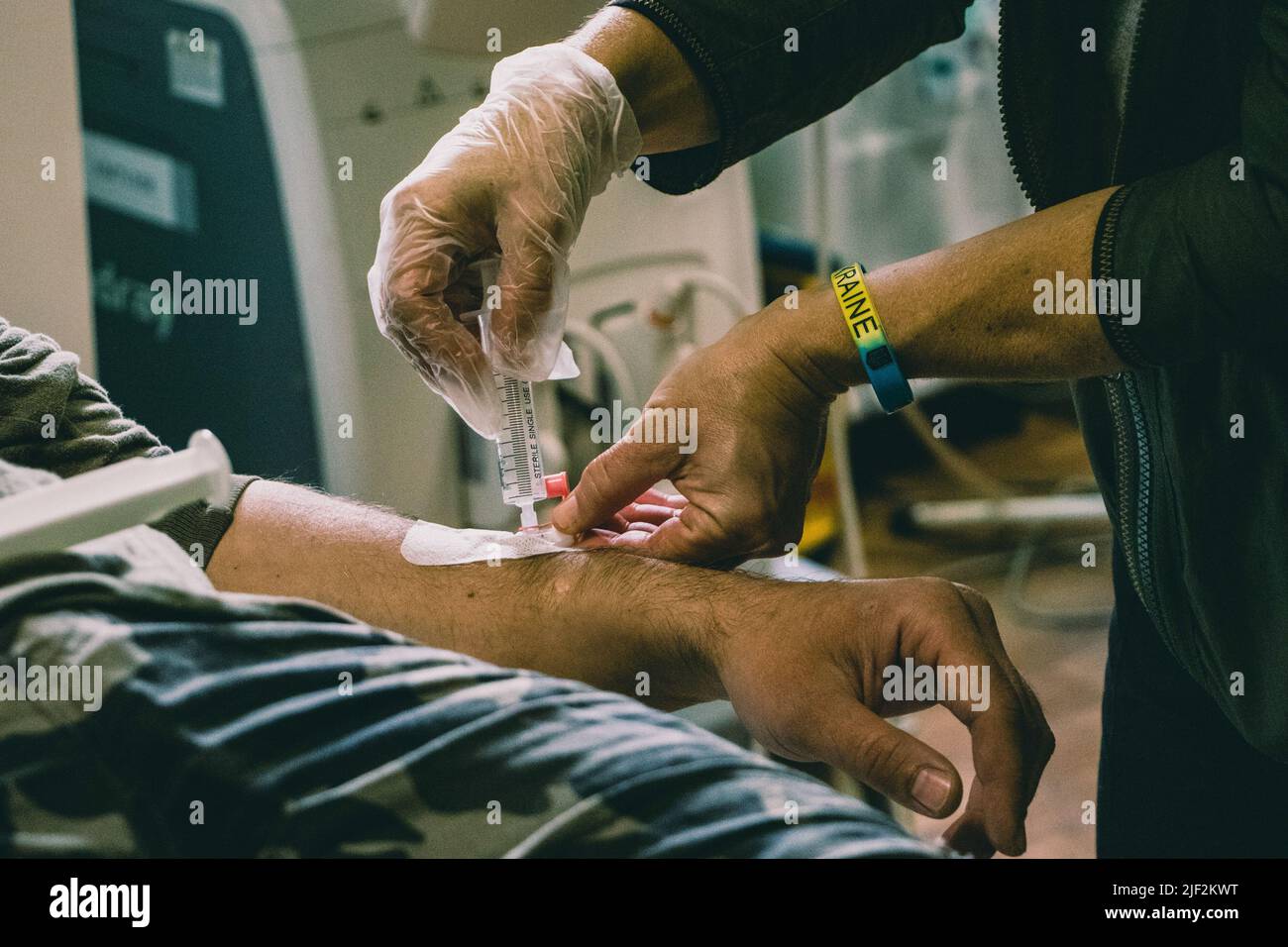 Doctor injects a pain reliever to a soldier. The military hospital in ...