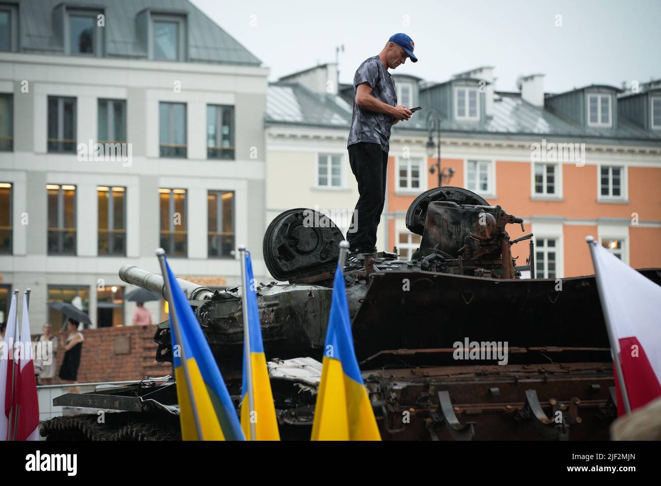 A man is taking photos while standing on a tank after trespassing an ...