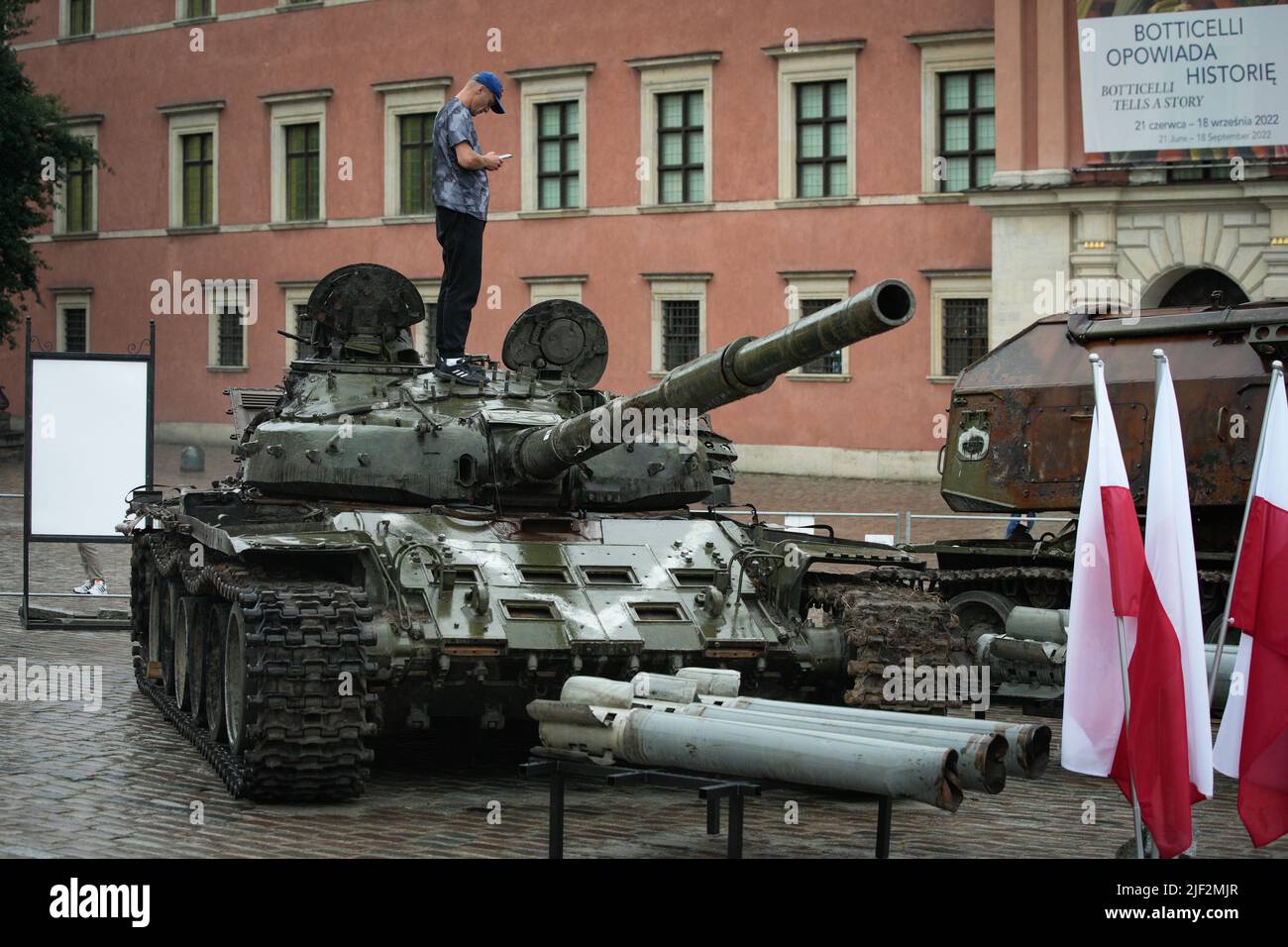 A man is taking photos while standing on a tank after trespassing an ...