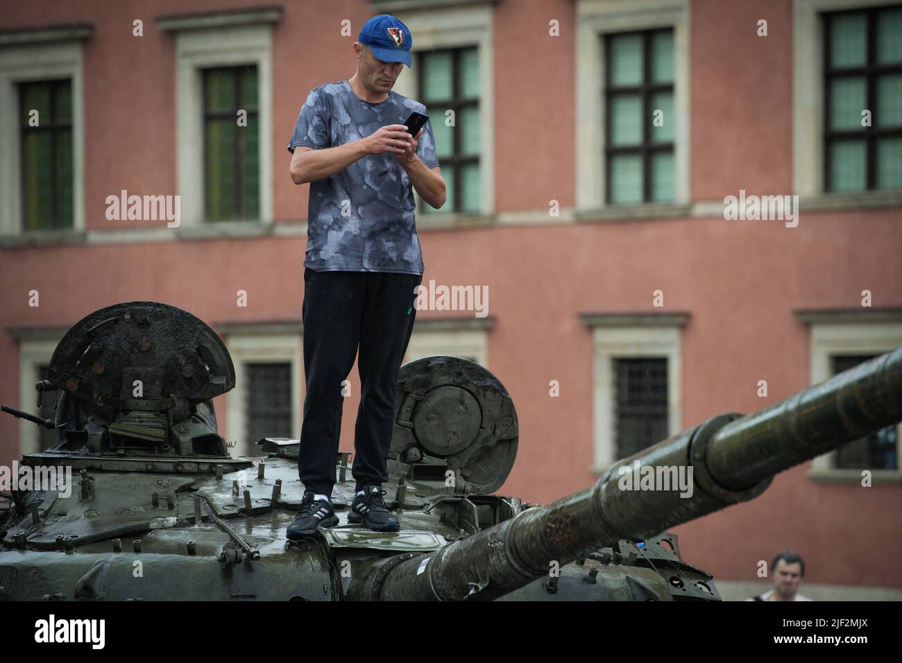 A man is taking photos while standing on a tank after trespassing an ...