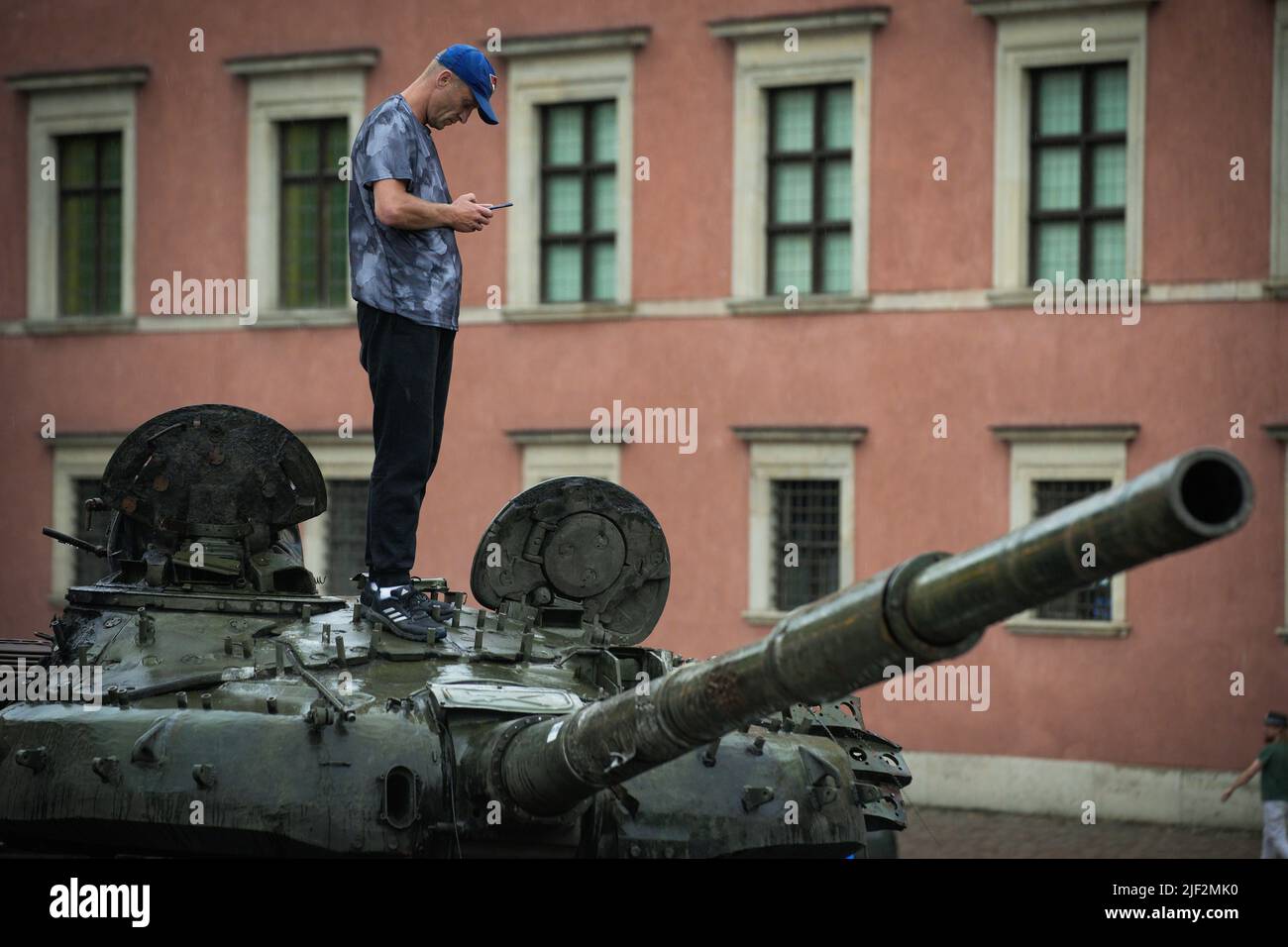 A man is taking photos while standing on a tank after trespassing an ...