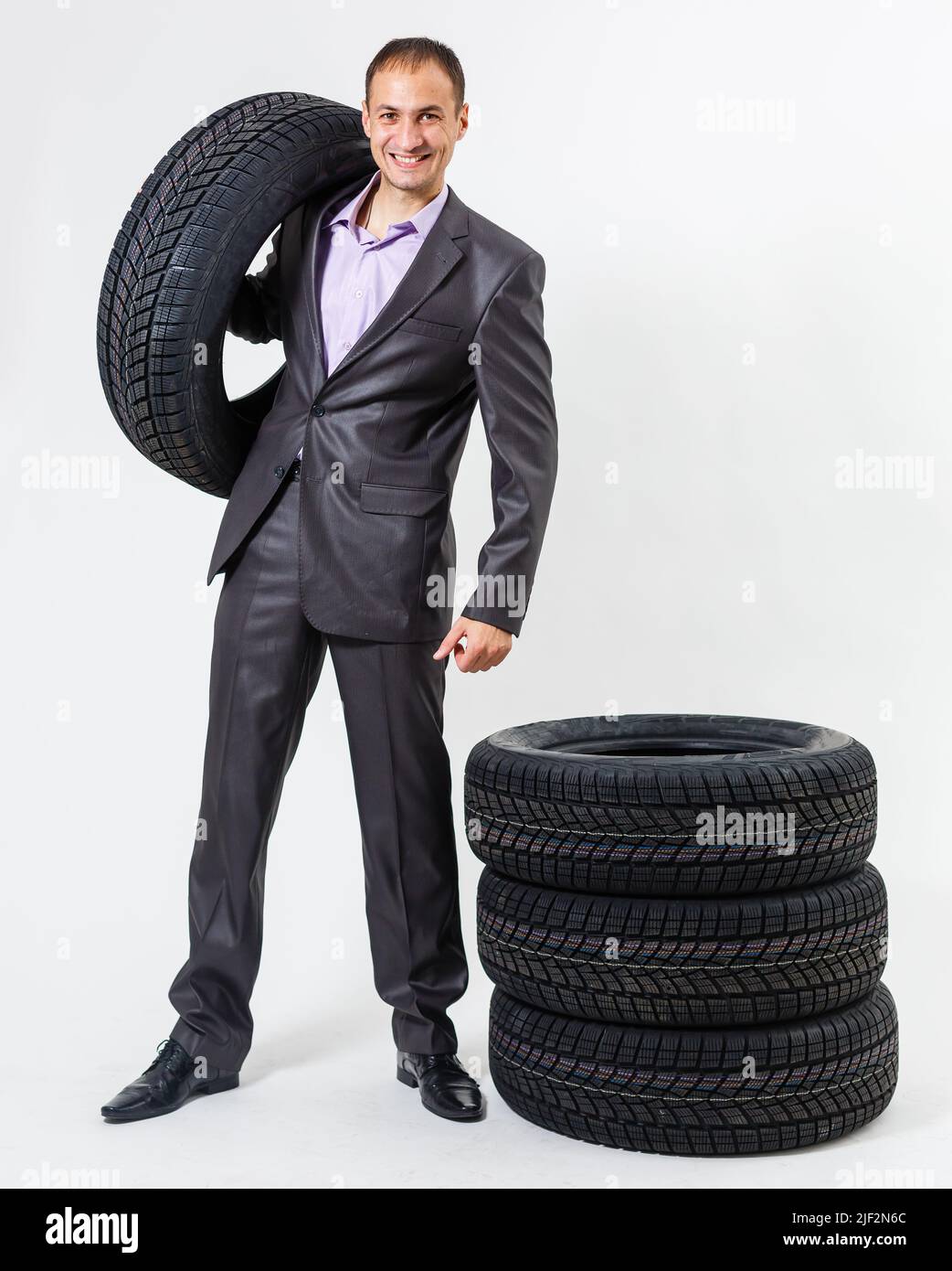 Car dealer man over tire tire background. Auto maintenance Stock Photo ...