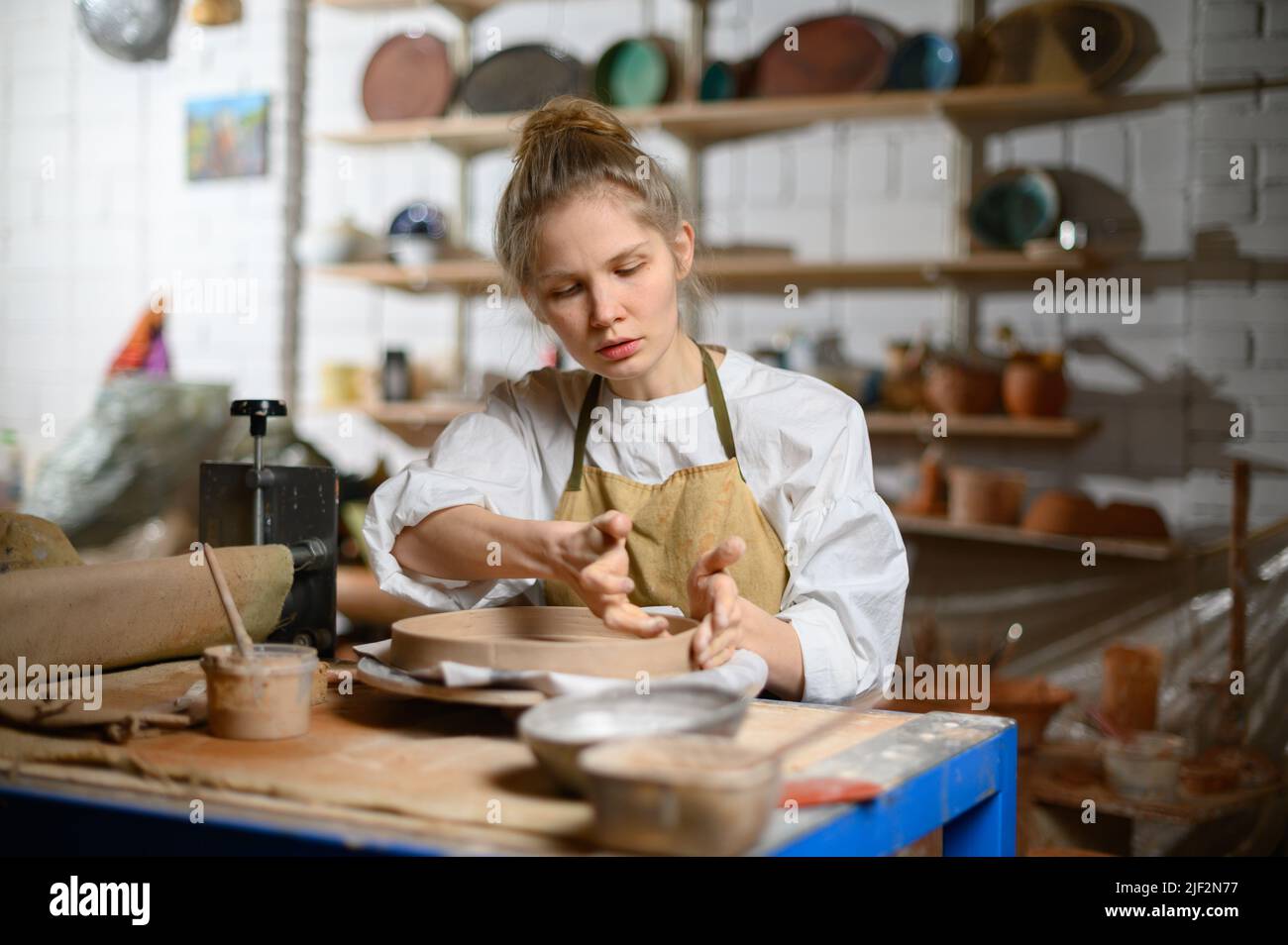 Girl make clay plate in ceramic workshop Stock Photo - Alamy