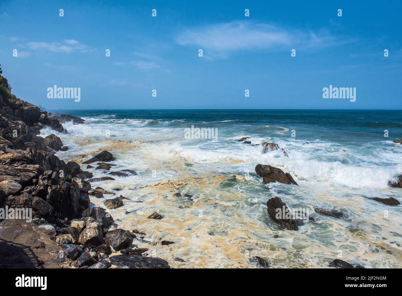 The huge waves crashing into ston island against the blue sky and ...